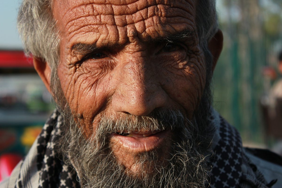 Old Man on the Side of the Road. He is sitting there on the pavement ...