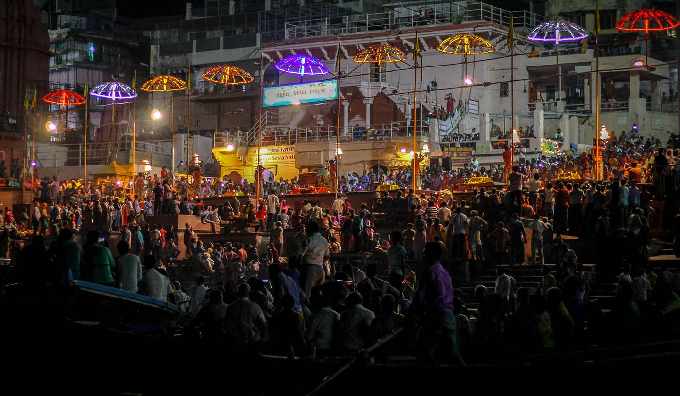 A crowded ceremony in Varanasi. On one side of the Ganges River, bodies ...