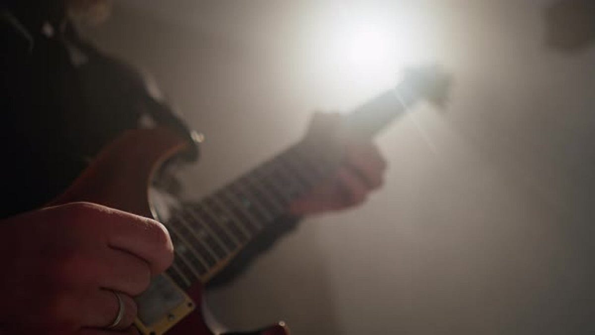 Guitarist Playing Red Guitar Under Dramatic Spotlight - Solarscribe ...