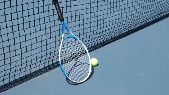 elevated view of the net of a blue tennis court and a ball. Racket ...