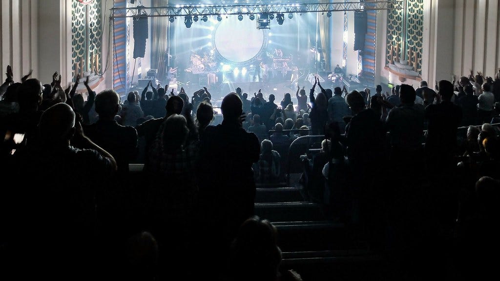 One Person Standing Up In A Crowd