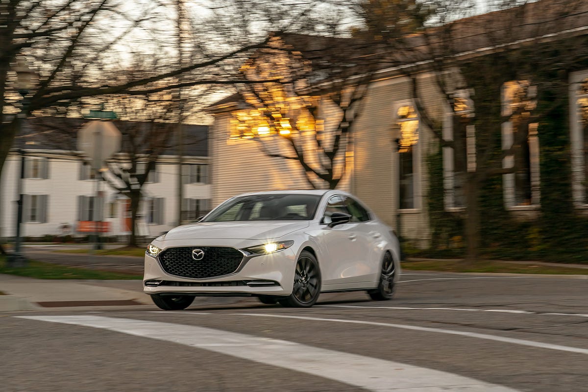 The exterior of the Mazda 3 is sleek and modern, with a stylish grille ...