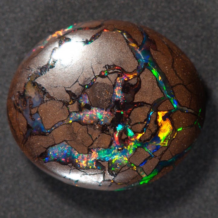 Brilliant Gemstone Resembles a Prismatic Universe Bursting Out of Wood ...